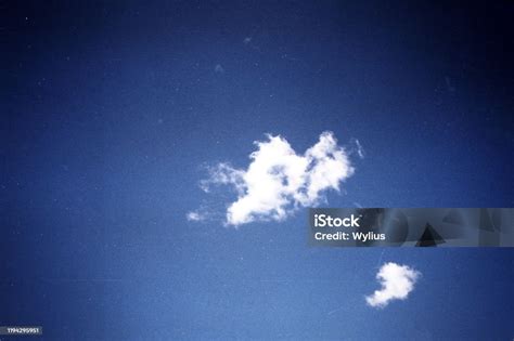 Grunge Image Of Blue Sky With A Cloud On Grainy Film Texture Stock