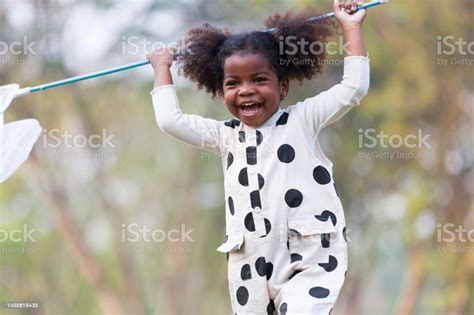 정원에서 쓰레받기를 들고 있는 아프리카계 미국인 소녀 어린 소녀는 공원에서 야외에서 자선 활동을 하고 놀고 있습니다 야외에서 가방에 쓰레기를 모으는 소녀 2 3 살에 대한