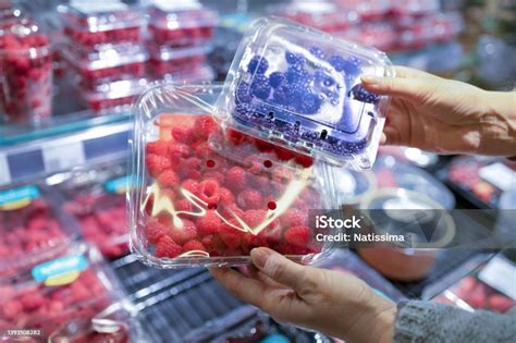 한 여성의 손이 슈퍼마켓에서 신선한 딸기와 라스베리를 따냅니다 신선하고 유기적이며 건강한 제품의 다양한 선택 라즈베리에 대한 스톡 사진 및 기타 이미지 Istock