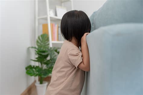 어린 아시아 아이들 어린 소녀는 손으로 눈을 가리고 벽 집 옆에 서서 숨바꼭질을 하고 집에서 즐거운 시간을 보내는 사랑스러운 아이 행복한 가족은 아이들과 즐거운 시간을
