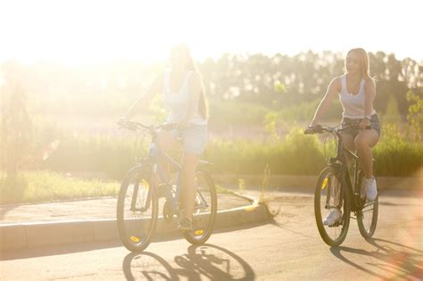 Premium Photo Two Girls Riding A Bike In A Beautiful Day
