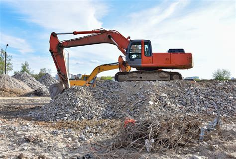 굴삭기는 매립지에서 콘크리트 철거 폐기물로 작업합니다 건물 및 건축 자재를 구출하고 재활용합니다 산업 폐기물 처리 공장 콘크리트 재사용 0명에 대한 스톡 사진 및 기타