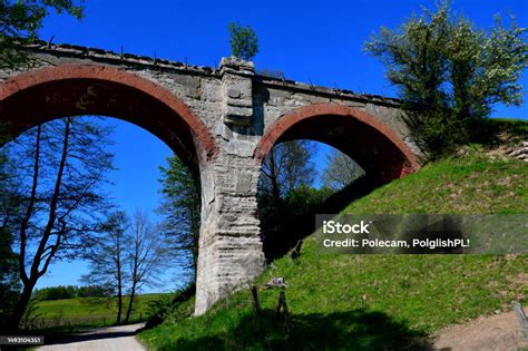 폴란드에서 볼 수 있는 언덕 숲 황무지로 둘러싸인 들판 한가운데에 위치한 콘크리트 붉은 벽돌 및 기타 재료로 만든 오래되고 버려지고 손상된 트랜 다리를 클로즈업합니다 0명에