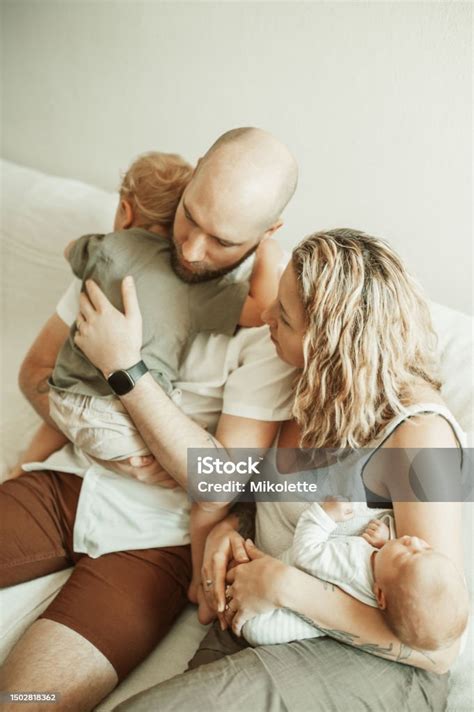 잠자는 자녀를 둔 부모 유대감과 사랑 유아와 신생아를 둔 남자와 여자 사랑과 보살핌 어린 시절 육아 소파에 누워 아이들과 함께하는 사람들 가족과 함께 시간을 보내는 사람들