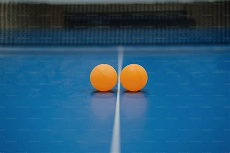 파란색 테이블 위에 있는 주황색 탁구공 두 개 사진 Unsplash의 스포츠 이미지