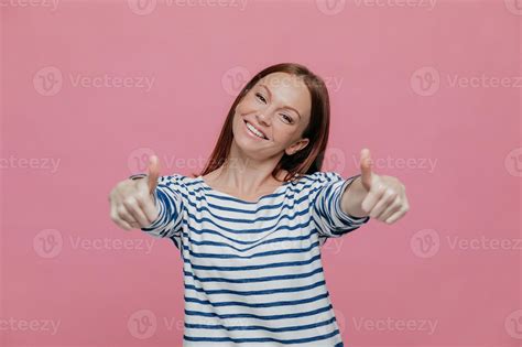 Joyful Beautiful Young Lady Raises Thumbs At Camera Shows That