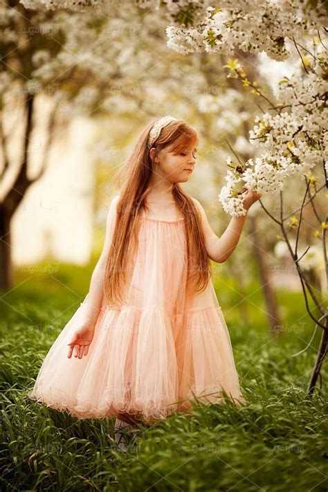 خرید و قیمت دانلود عکس با کیفیت دختر با لباس گلبهی در حال لذت بردن از گل های پاییزی ترب