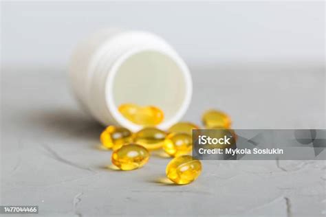 알약 병에서 오메가 3 오일이 쏟아져 나오는 소프트 젤 알약 젤 캡슐 병 흰색 표면 오메가 3 종합 비타민 칼슘 항생제 건강