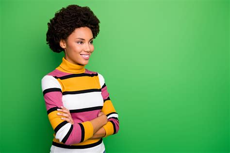 예쁜 어두운 피부 물결 모양의 비즈니스 레이디 팔 교차 빈 공간을 보고 동료 회의 친절 한 미소 착용 캐주얼 스트라이프 점퍼 고립 된 녹색 색상 배경 갈색 머리에 대한 스톡