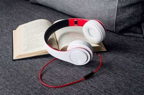 Premium Photo Open Book With Headphones On Gray Sofa Audio Book Concept Modern Education