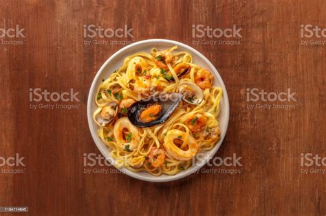 해물 파스타 홍합 새우 조개와 오징어 반지가 있는 Tagliolini 접시는 어두운 소박한 나무 배경의 상단에서 텍스트를 위한 장소를 촬영 합니다 0명에 대한 스톡 사진 및