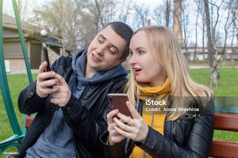 남자와 여자는 둘 다 데이트에 앉아 서 스마트폰에 한 모금 소셜 미디어 중독의 개념 현실에서 벗어나 서로를 무시 공원에서 그네에