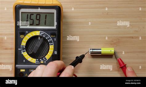 Testing AA Battery Cell With Digital Multimeter Tool Voltage Check