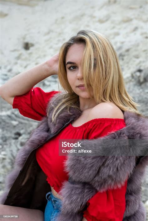 자연의 모래 바위에 모피 코트를 입고 꽤 행복한 날씬한 여자 건강한 생활방식에 대한 스톡 사진 및 기타 이미지 건강한 생활