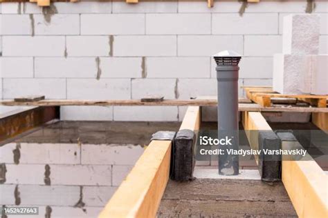 1 층과 2 층 사이의 칸막이를위한 목재 빔과 집을 짓는 과정에서 지하실에서 배출되는 배기 가스 바닥재에 대한 스톡 사진 및