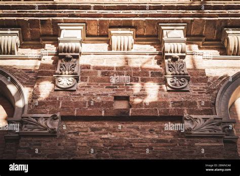 Neoclassical Capital On The Cornice Of An Old Red Brick Building Stock