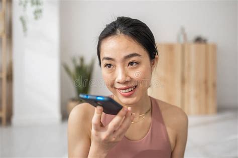 Happy Young Fitness Asian Woman Sending Voice Message Through Cell Phone App Stock Image