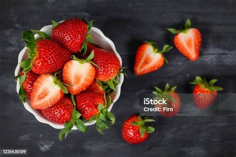 신선한 잘 익은 전체를 보여주는 그릇에 딸기와 어두운 배경에 흰색 그릇에 절반 딸기 과일을 잘라 0명에 대한 스톡 사진 및 기타