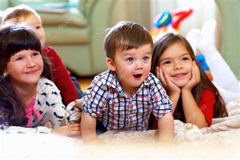 Grupo De Niños Felices Viendo La Televisión En Casa — Foto De Stock 14806727 © Olesiabilkei