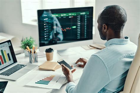 사무실에서 일하는 동안 컴퓨터를 사용하는 셔츠를 입은 젊은 아프리카 남자의 뒷모습 사진 Unsplash의 남자 이미지