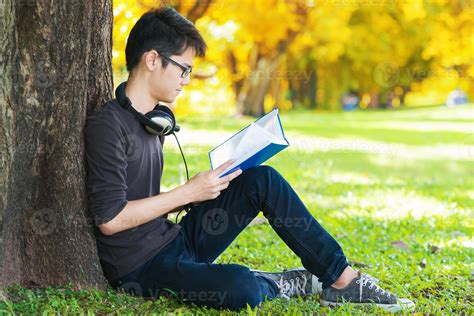 Man Reading Book In Park Sitting Under A Tree 865150 Stock Photo At Vecteezy