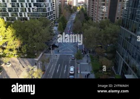 A Low Flying Aerial View Along A Tree Lined Urban Street Capturing A