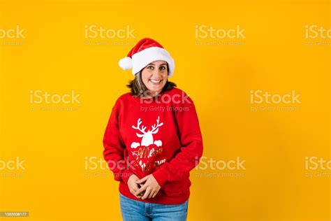 멕시코 라틴 아메리카의 노란 배경에 크리스마스 선물 상자를 들고 라틴 어 성인 여성의 초상화 12월에 대한 스톡 사진 및 기타 이미지 Istock