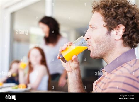 Man Drinking Glass Of Orange Juice Stock Photo Alamy