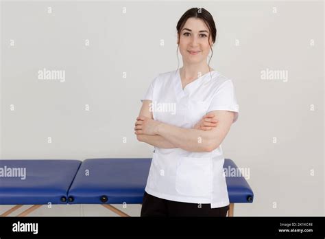 Portrait Of Young Smiling Confident Masseuse Therapist Doctor Woman Wearing White Uniform