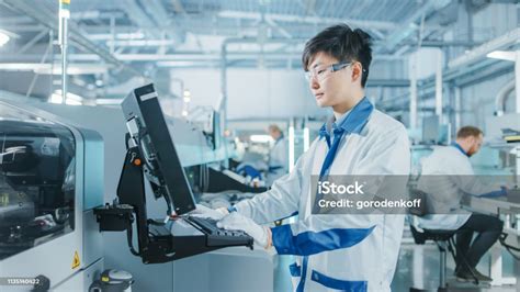 하이테크 공장에서 아시아 엔지니어는 프로그래밍을 위한 컴퓨터를 사용 하 여 인쇄 회로 기판 표면 실장 조립 라인에 대 한 전자