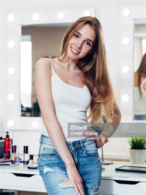 캐주얼 저지 뷰티 살롱에서 조명이 메이크업 거울에 대 한 포즈를 취하는 청바지를 입고 긴 금발 머리와 귀여운 웃는 여성 모델 가냘픈에 대한 스톡 사진 및 기타 이미지