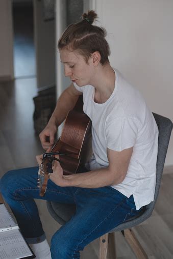 나무 어쿠스틱 기타에서 로맨틱한 노래를 연주하는 어린 아름다운 소년의 측면 보기는 자신의 집에서 코비데 카란테나 동안 자신의 자유 시간을 보내고 25 29세에 대한 스톡