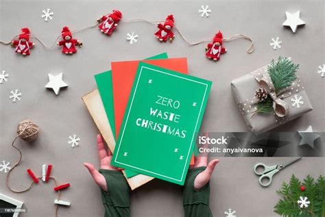 환경 친화적 인 대안 Xm 제로 폐기물 크리스마스 평면 평신도 공예 종이 배경에 상단보기 섬유 인형 화환 텍스트 제로 폐기물 크리스마스와 빨간색과 녹색 색상 종이를 들고