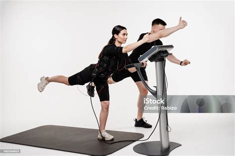 근육을 활성화하기 위해 전기 자극을 가하는 Ems 슈트를 입은 그룹 운동 훈련 트레이너는 Ems 전기 근육 자극 슈트를 사용한 운동의 예를 보여줍니다 18 19세에 대한