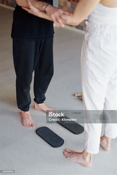 손톱에 서있는 연습 여자는 요가 스튜디오에서 손톱으로 Sadhu 보드에 남자가 서도록 도와줍니다 손톱이 달린 Sadhu 보드는 훈련 후 힘을 회복합니다 건강한 생활방식에