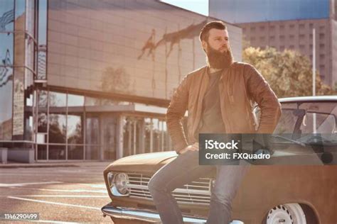 밝은 석양에 마천루 근처 도시 주차장에서 조정 복고풍 자동차에 기대어 세련 된 남성 가을에 대한 스톡 사진 및 기타 이미지