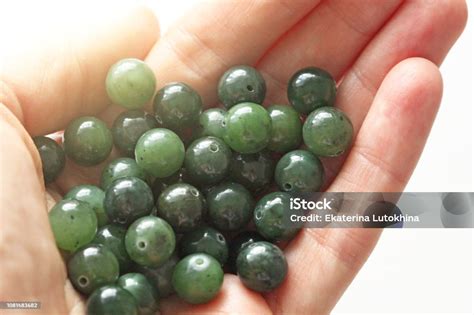 자연 그린 옥 네 프 라이트 미네랄 돌 구슬 녹색 옥 돌 손에 놓여 있습니다 흰색 바탕에 돌 들고 손입니다 녹색 잔디 자연 배경 둥근 돌 구슬의 거친에 대한 스톡 사진 및