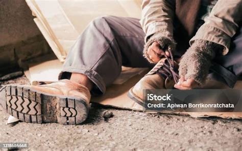 노인 노숙자는 스웨터와 천 장갑을 착용하고 골판지에 앉아 신발에 끈을 묶습니다 홈리스에 대한 스톡 사진 및 기타 이미지 홈리스 노숙자 노숙자 보호시설 Istock