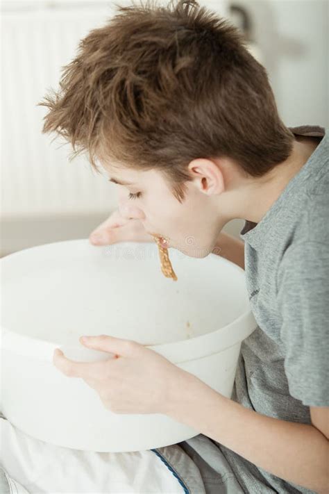 Unwell Young Boy Throwing Up Into A Bowl In Bed Stock Image Image Of