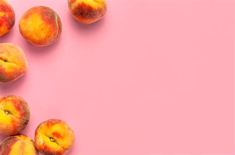 분홍색 배경에 녹색 잎이 달린 익은 육즙이 많은 복숭아 플랫 레이 상단보기 복사 공간 복숭아로 최소한의 창조적 인 구성 신선한 유기농 과일 비건 식품 수확 개념 먹기에 대한