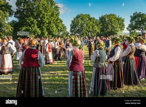 People In Folk Costumes And Herbal Wreaths Celebrate Midsummer In