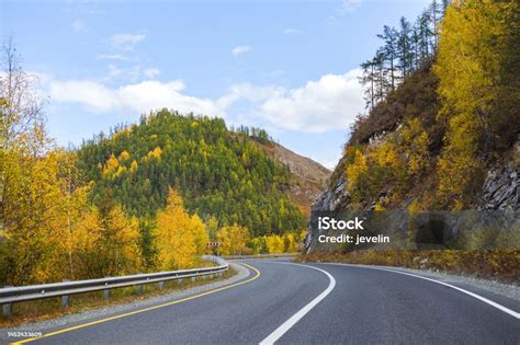 높은 눈 덮인 산 봉우리 노란 사막 가을 녹색 숲과 푸른 하늘 사이의 뱀 아스팔트 도로 마운트 풍경의 배경에 대한 고속도로의 자동차 가을에 대한 스톡 사진 및 기타 이미지