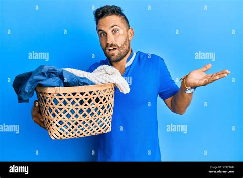 Handsome Man With Beard Holding Laundry Basket Celebrating Achievement