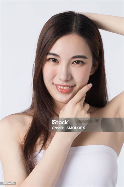 긴 갈색 머리와 흠잡을 데 없는 피부를 가진 아름 다운 젊은 아시아 여성의 초상화 미소 짓고 얼굴을 만지고 있습니다 갈색 머리에 대한 스톡 사진 및 기타 이미지 Istock