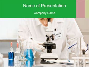 Laboratory Research Scientist In Lab Coat And Rubber Gloves Examining Specimen Under Microscope