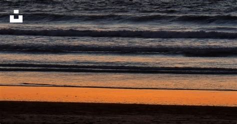 태양은 해변의 바다 위로 지고 있습니다 사진 Unsplash의 무료 바닷가 이미지