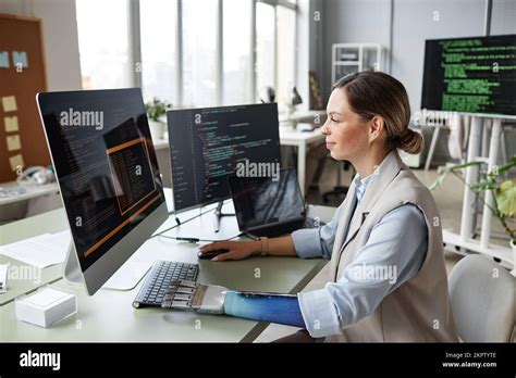 Positive Software Developer With Bionic Arm Checking Code On Computer