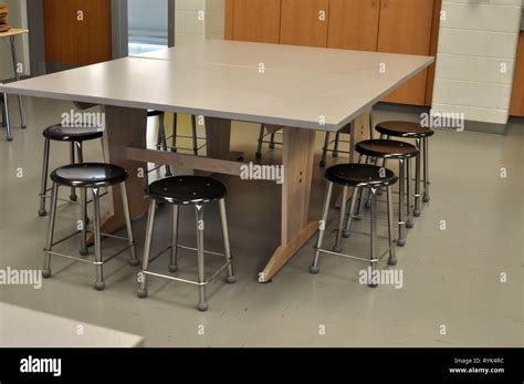 A Large Table With Stools All Around On The Interior Of An Art