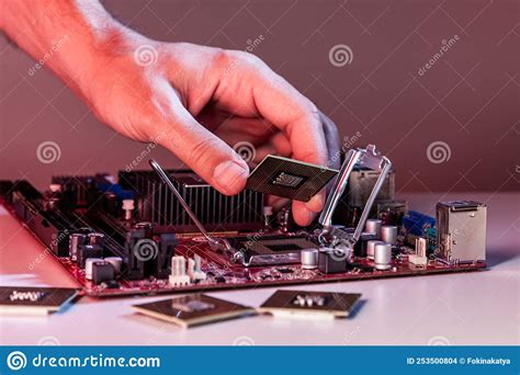 Una Mano Mans Inserta Un Procesador En El Chipset De La Motherboard Foto De Archivo Imagen De