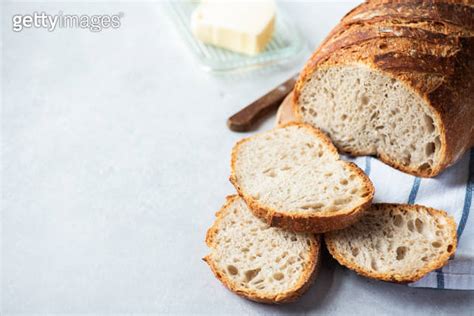 Homemade Artisanal Sliced Sourdough Bread On A Napkin And Butter With